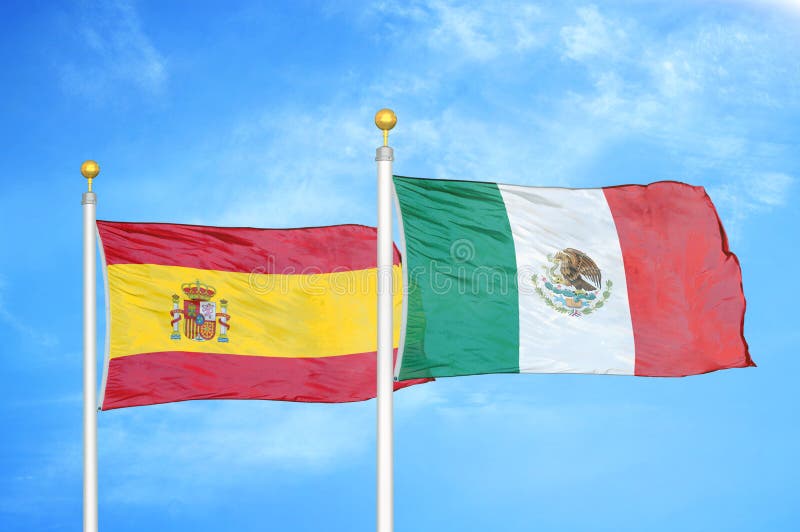 Spain and Mexico Two Flags on Flagpoles and Blue Cloudy Sky Stock Image ...