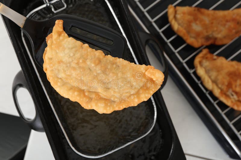 Spatula with Delicious Fried Chebureki Over Deep Fryer, Top View Stock ...