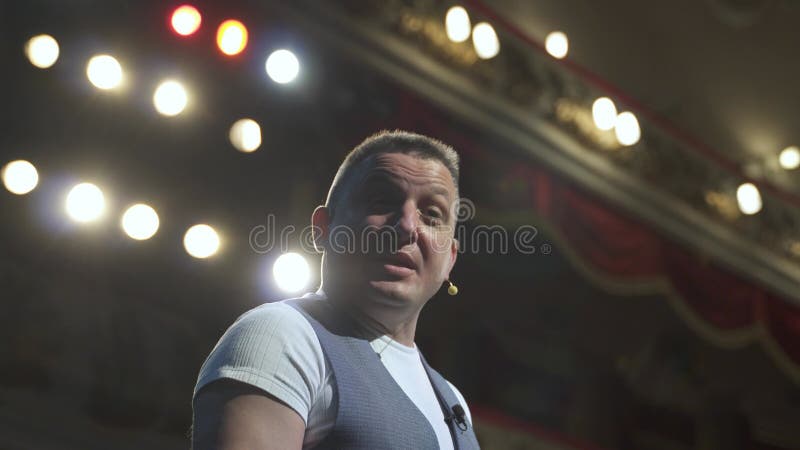 Speaker Man in a Vest Performs on the Stage of the Concert Hall Against ...