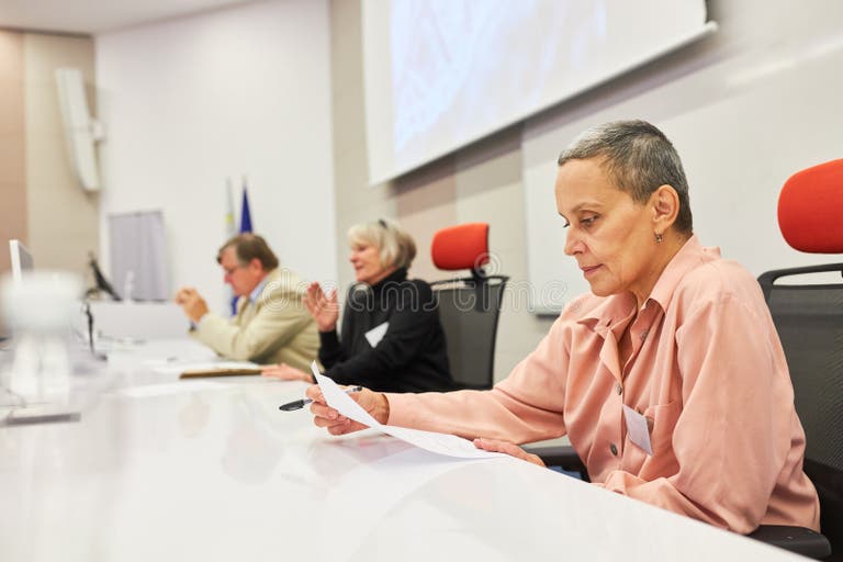 Speaker Reading Document at Table in Convention Center Stock Photo ...