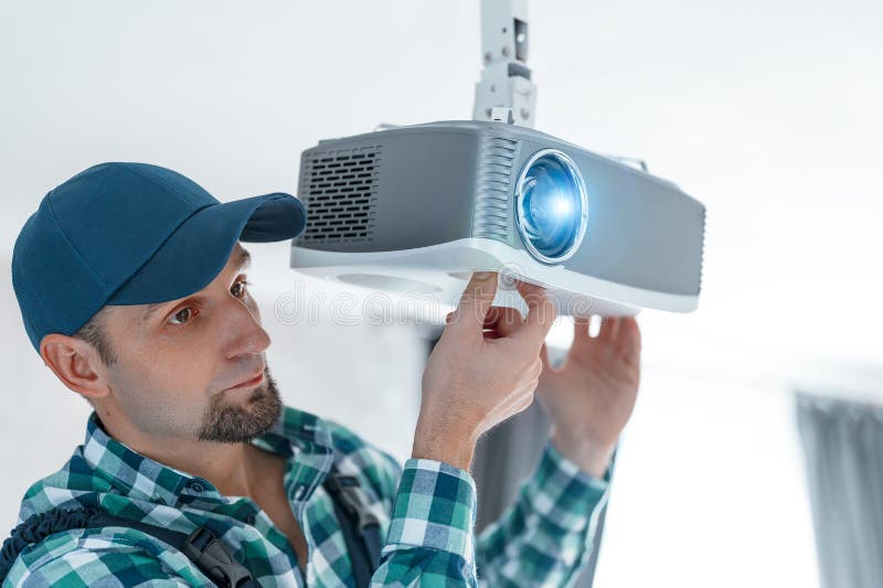 A Specialist Adjusts the Focus of a Multimedia Video Projector for Home ...