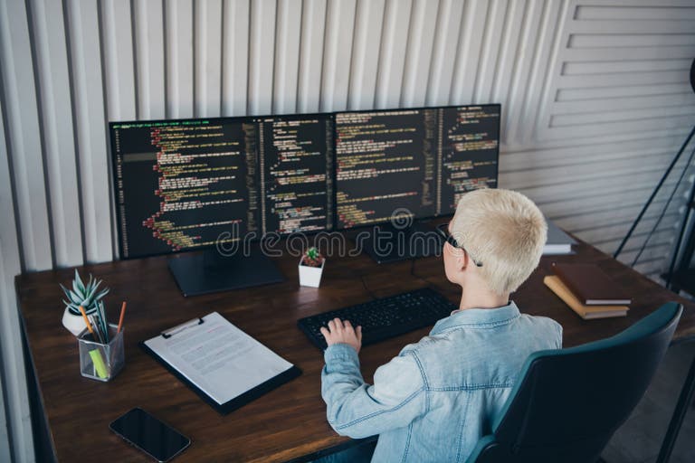 Programmer Working on Dual Screens in Modern Workspace with Casual ...
