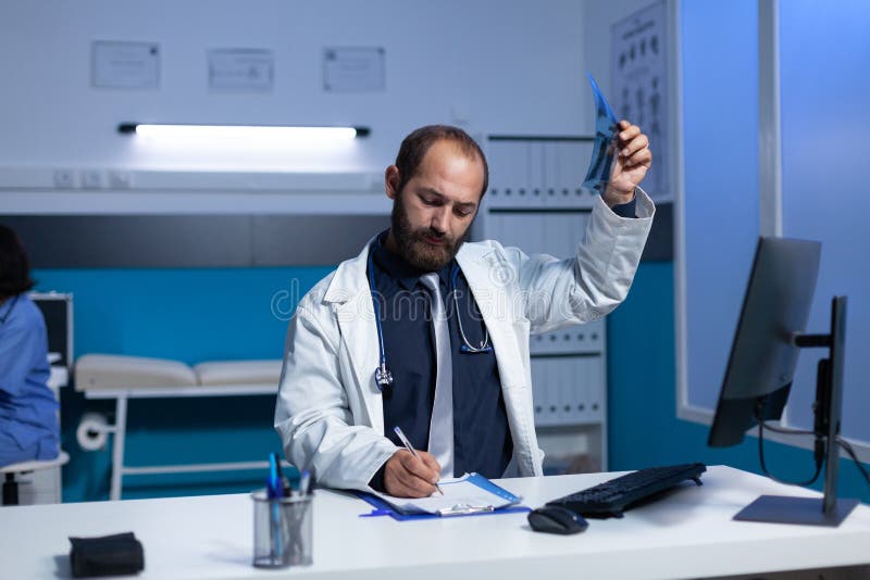 Specialist Holding X Ray Scan for Examination while Taking Notes Stock ...