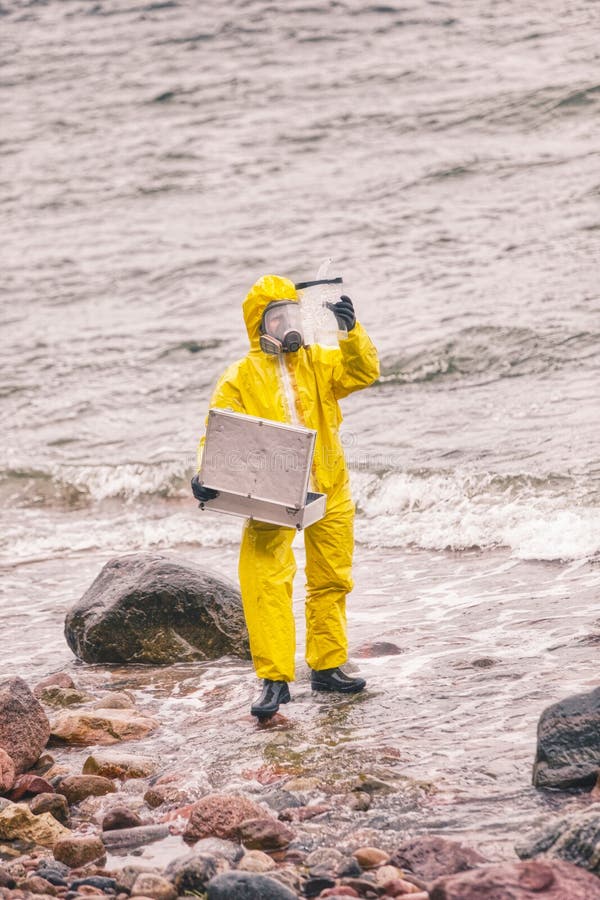 Specialist in Protective Suit Checking Sample of Water on Rocky Sea ...