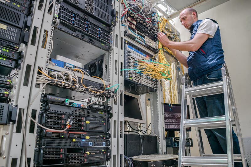 The Specialist Works in the Server Room of the Data Center. Worker Lays ...