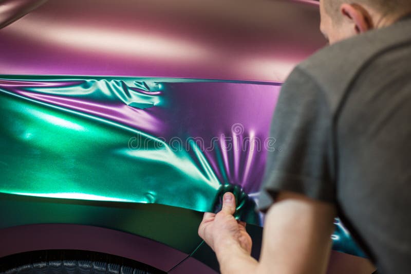 A Specialist in Wrapping a Car with Chameleon-colored Vinyl Film in the ...