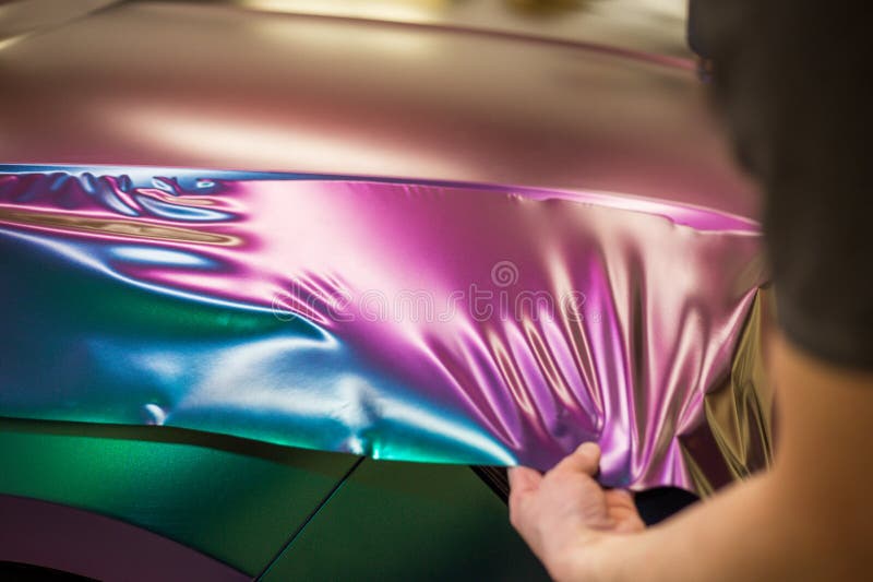 A Specialist in Wrapping a Car with Chameleon-colored Vinyl Film in the ...