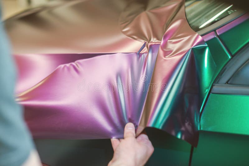 A Specialist in Wrapping a Car with Chameleon-colored Vinyl Film in the ...