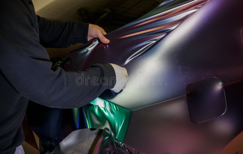 A Specialist in Wrapping a Car with Chameleon-colored Vinyl Film in the ...