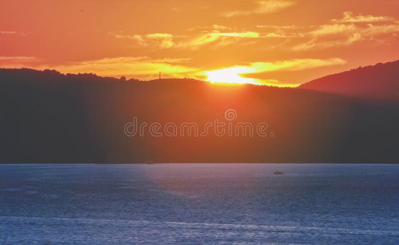 Spectacular Sunset Behind a Mountain at Sea Stock Photo - Image of ...