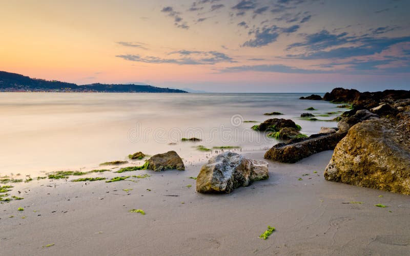 Spiaggia Con Le Rocce Al Tramonto Immagine Stock - Immagine di mare ...
