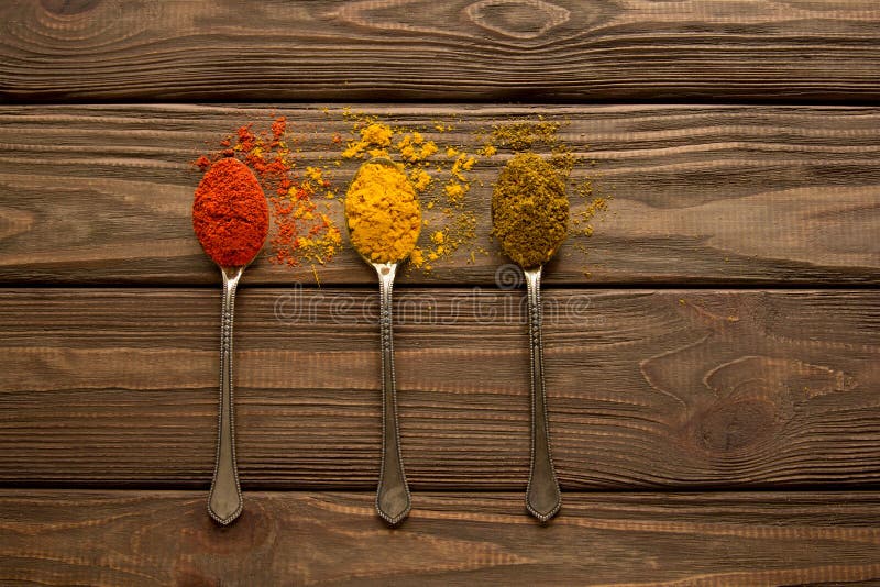 Spice Powder on Wooden Background. Three Spoons with Various Spices ...