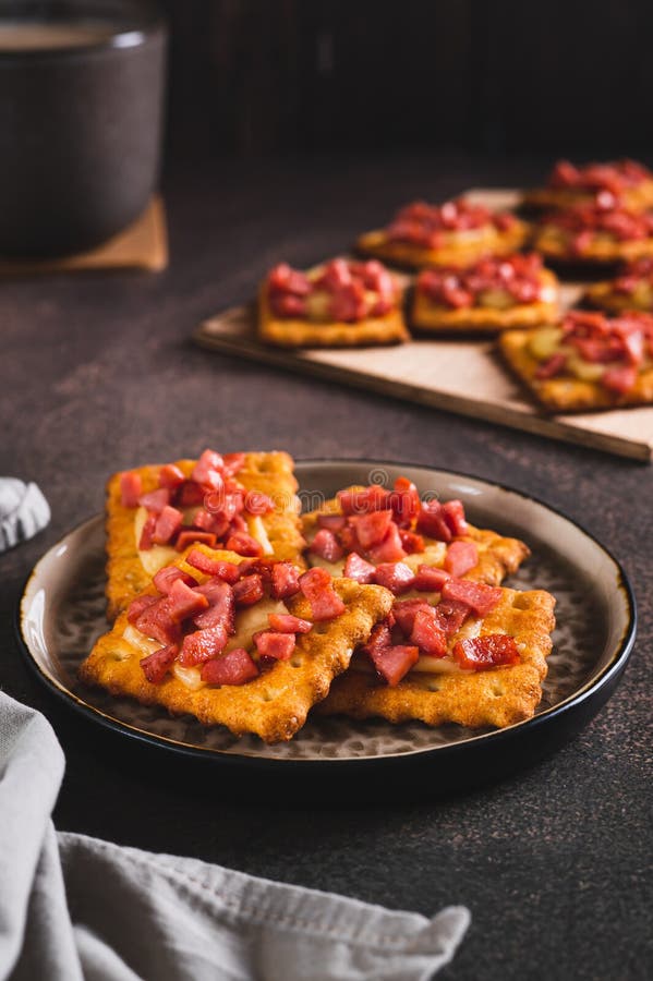 Spicy Baked Crackers with Cheese and Sausage on a Plate on the Table ...