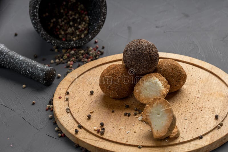 Spicy Cheese Covered with Round Type Spices on a Wooden Surface Stock ...
