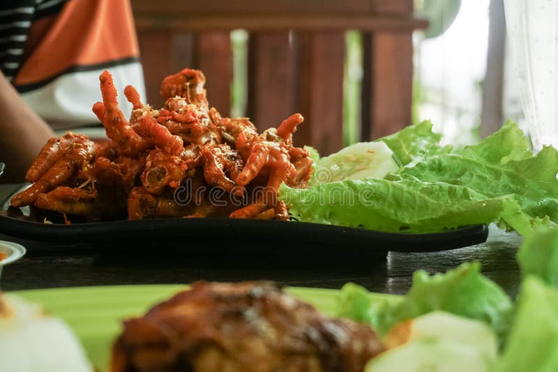Spicy Chicken Feet on a Black Rectangular Plate on the Dining Table ...