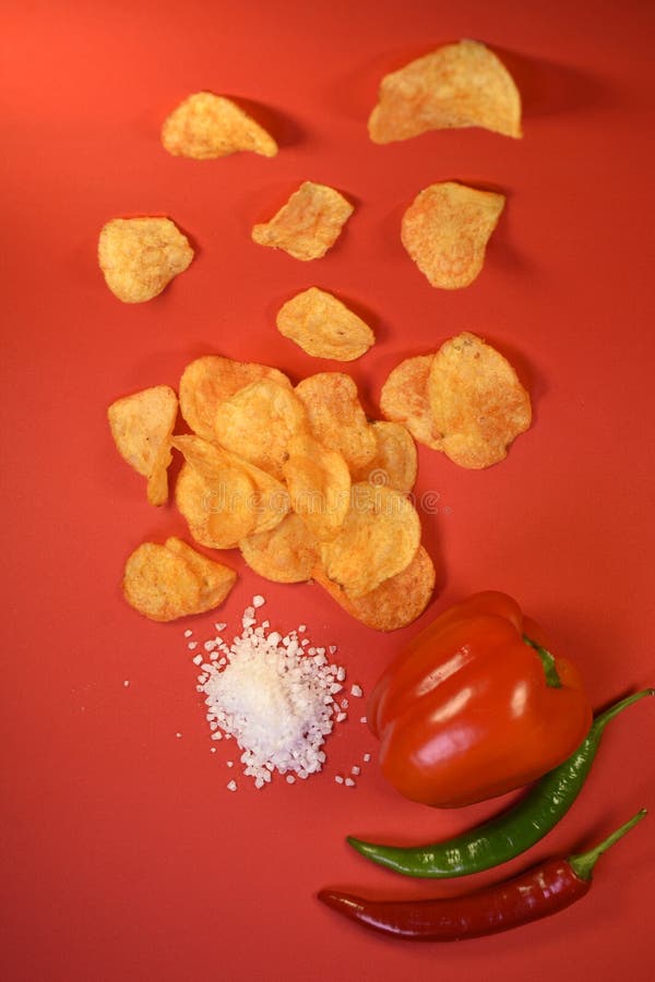 Spicy Chips Scattered on the Surface with Pepper and Salt on a Red ...