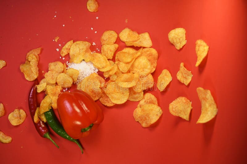 Spicy Chips Scattered on the Surface with Pepper and Salt on a Red ...