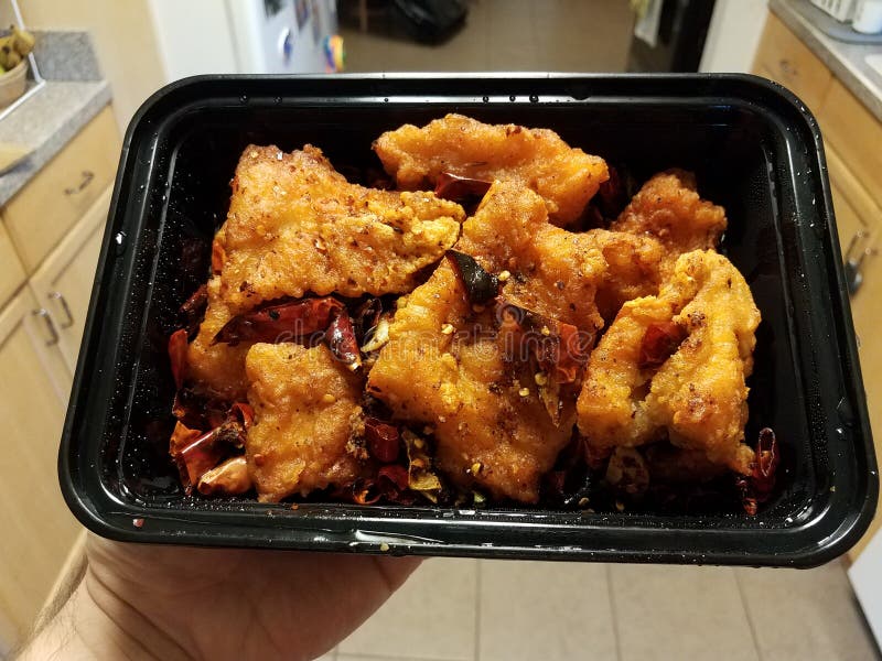 Spicy Fried Chinese Fish with Peppers in Container in Kitchen Stock ...