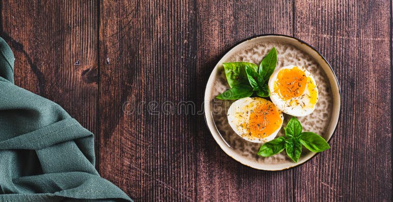 Spicy Soft-boiled Egg Halves and Basil on a Plate on a Table Top View ...