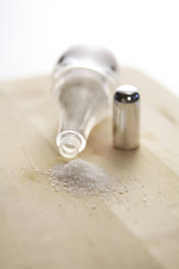 Spilled Salt and Salt Shaker on on a Black Stone Table, Selective Focus ...