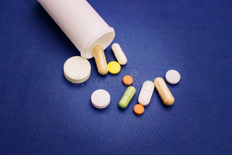 Tablets from a Vial on a Blue Background Stock Image - Image of ...