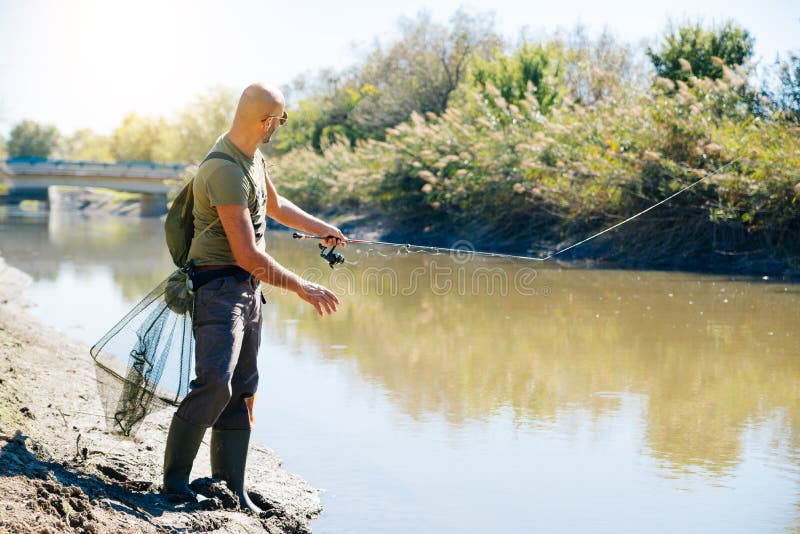 Spin fishing on a river stock image. Image of fisher - 184829953
