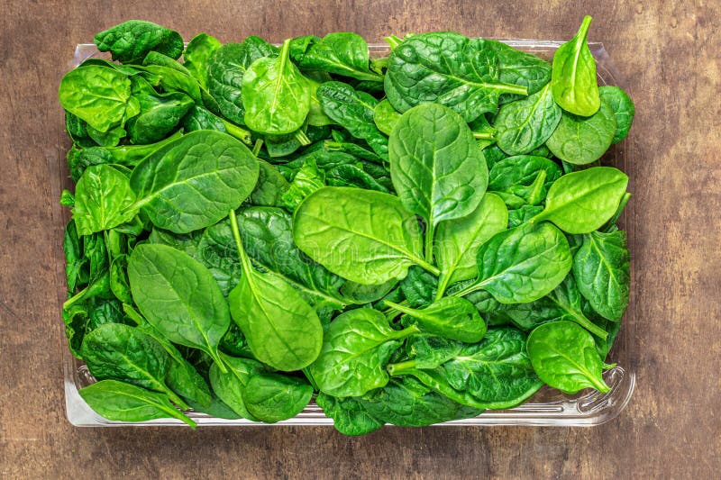 Spinach Leaves in a Plastic Box on Wooden Table. Fresh Spinach Closeup ...