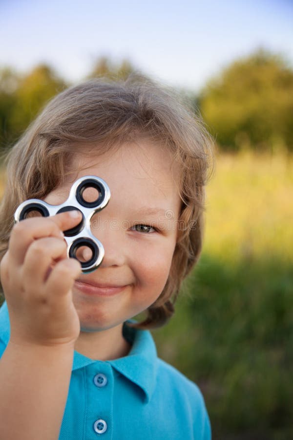 Spinner in the Hand of a Child Smiling in the Nature on a Summer Stock ...