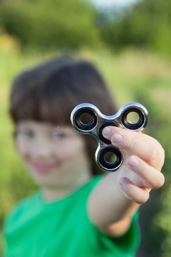 Spinner in the Hand of a Child Smiling in the Nature on a Summer Stock ...