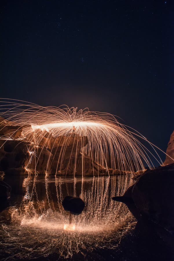 Spinning Fire with the Blue Sky and Water Reflection Stock Image ...