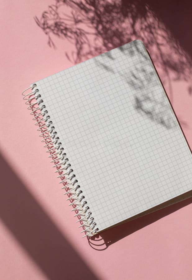 Spiral Checkered White Paper Notepad on the Pink Table with Leaves ...