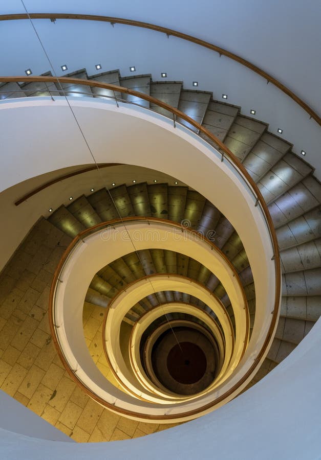 Spiral Staircase Leads Down Several Floors with Dramatic Lighting Stock ...