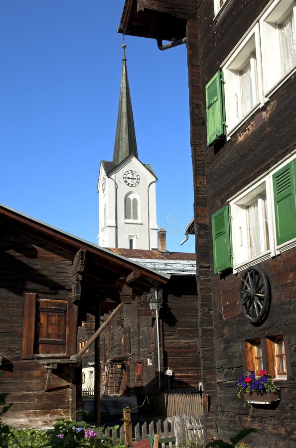 Spire behind Swiss chalets stock photo. Image of apartment - 25771990
