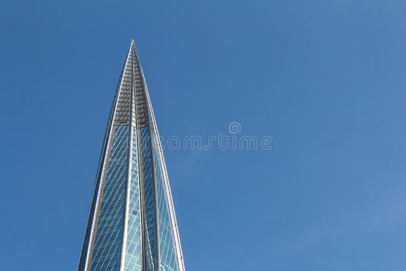 The Spire of the Office Building is Made of Glass Against the Blue Sky ...
