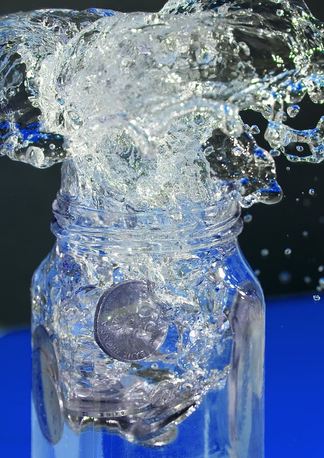 Splash of Water and Coins in a Glass Stock Photo - Image of backlight ...