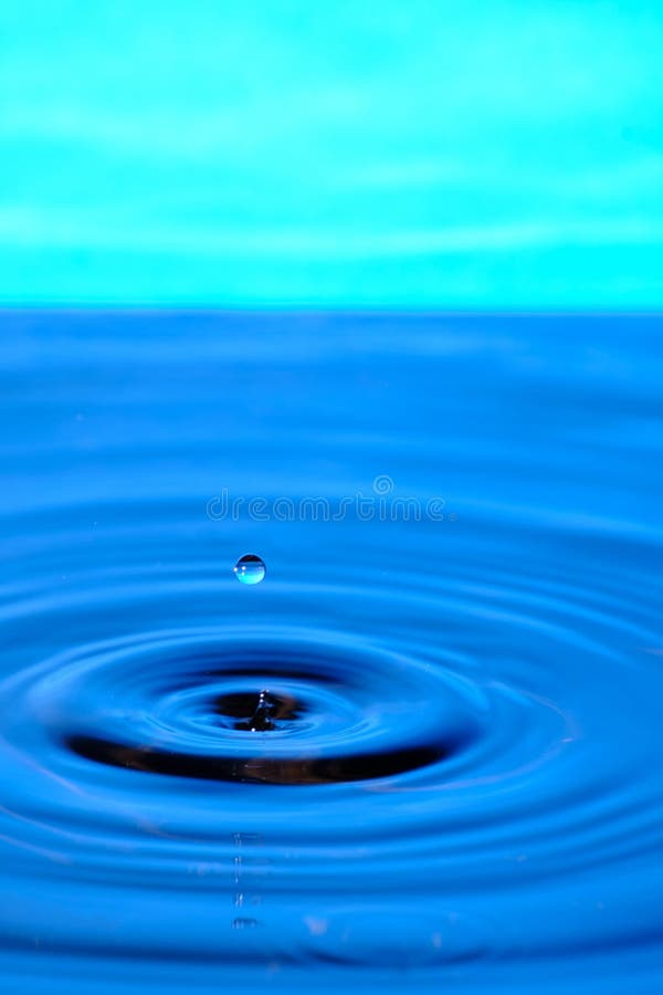 Splash Drop of Water with Diverging Water Circles, on Blue Background ...