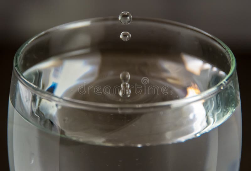 Splash from a Drop of Water Dropped into a Glass with Water Stock Image ...