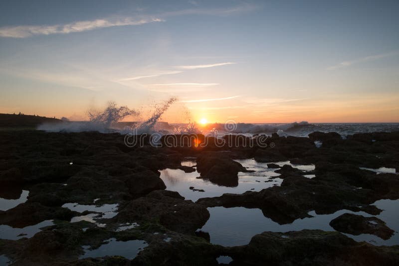 Splash of Ocean Waves Against a Background of Sunset and Rocks Stock ...
