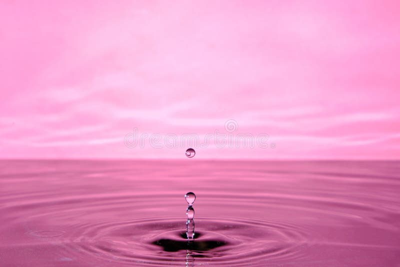 Splash Water after Drop Falls.Pink Abstract Background with Drop in ...