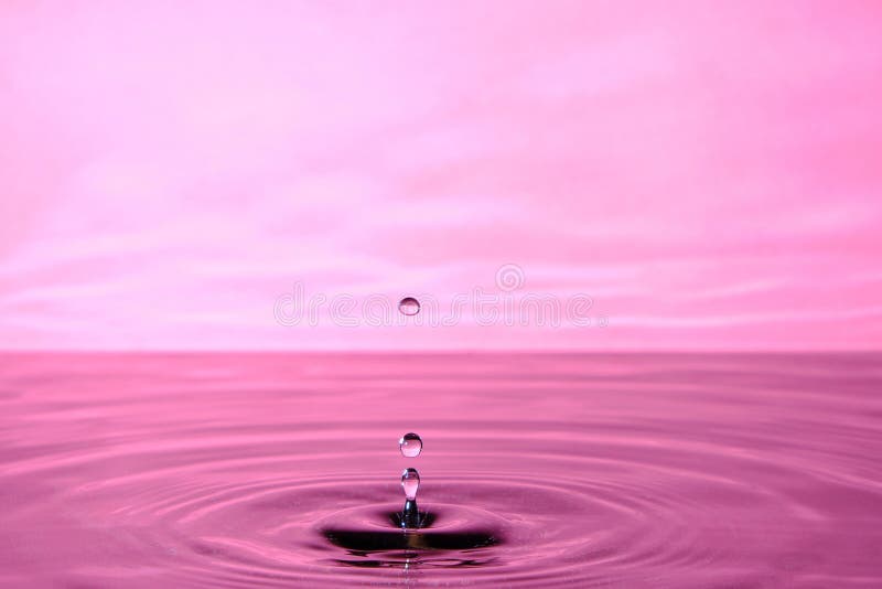 Splash Water after Drop Falls.Pink Abstract Background with Drop in ...