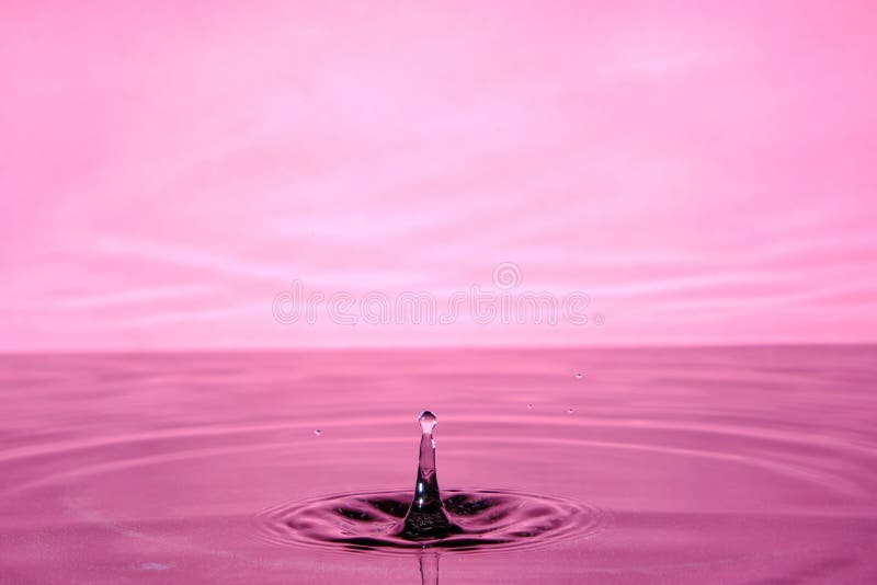 Splash Water after Drop Falls.Pink Abstract Background with Drop in ...