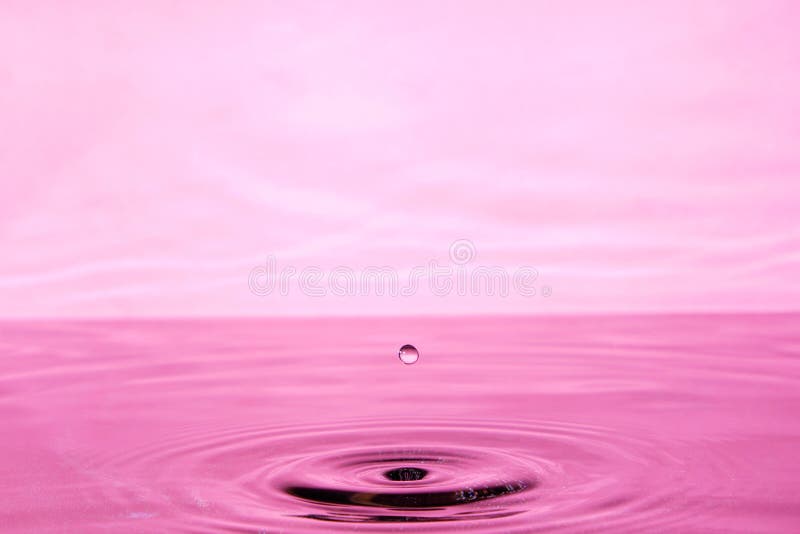 Splash Water after Drop Falls.Pink Abstract Background with Drop in ...