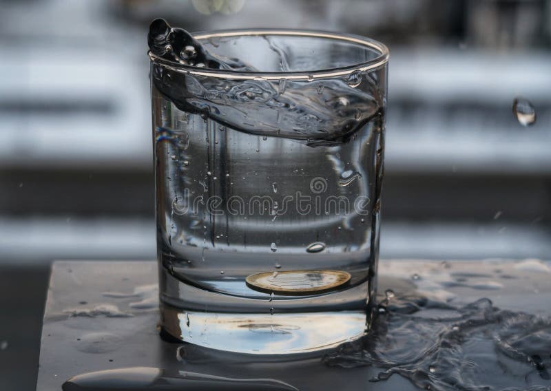 Splash of Water in a Glass from a Tossed Coin Stock Image - Image of ...