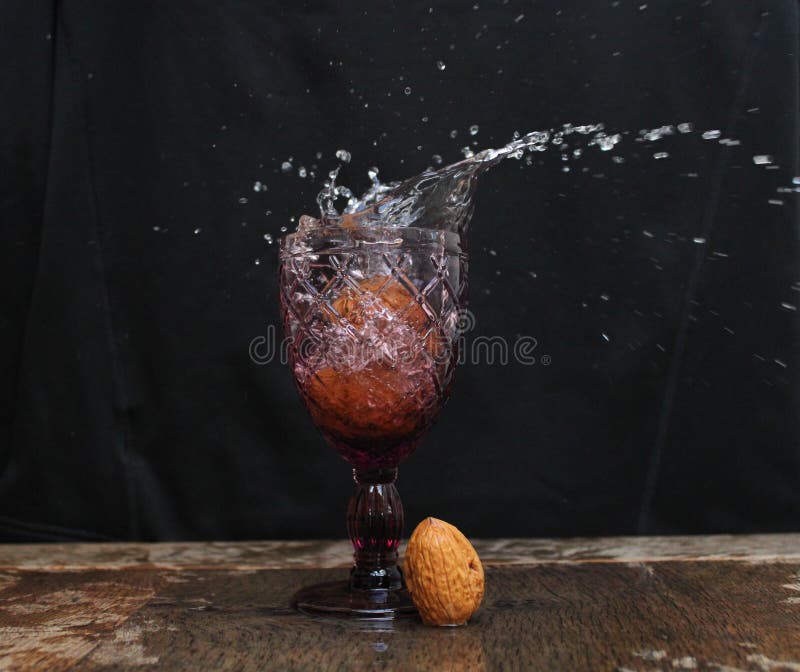 Splash of Water in a Glass with a Walnut Stock Photo - Image of closeup ...