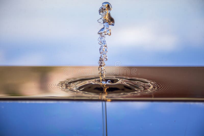 Splash of Water Jet Creating Waves As it Enters the Water Stock Photo ...