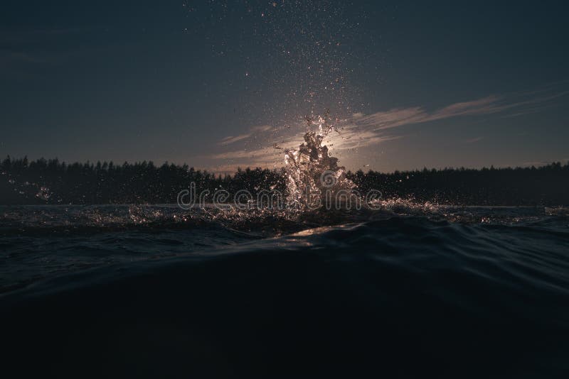 Splash of Water in a Pond Against the Backdrop of the Setting Sun Stock ...
