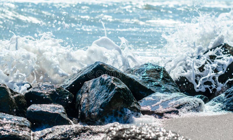 Splashes of Sea Waves on the Black Stones on the Sand of the Beach ...