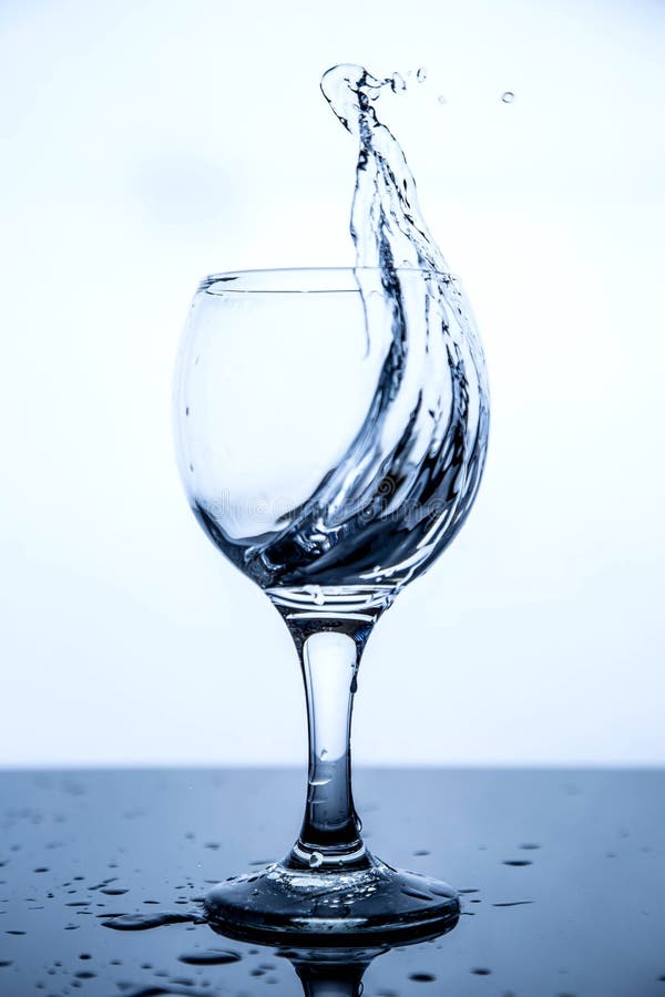 Splashing in a Glass of Clean Drinking Water on a Black Glass Table ...