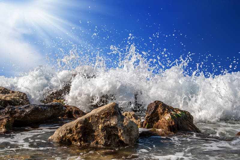 Splashing Sea Water on Rocks on a Bright Blue Sky Stock Image - Image ...