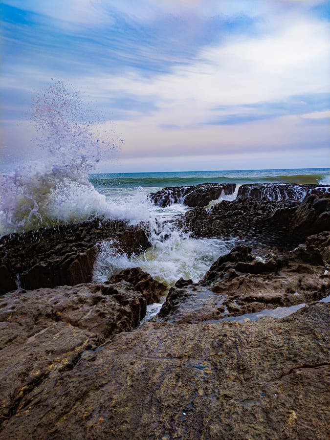 Splashing surf on rocks. stock image. Image of morning - 250446065